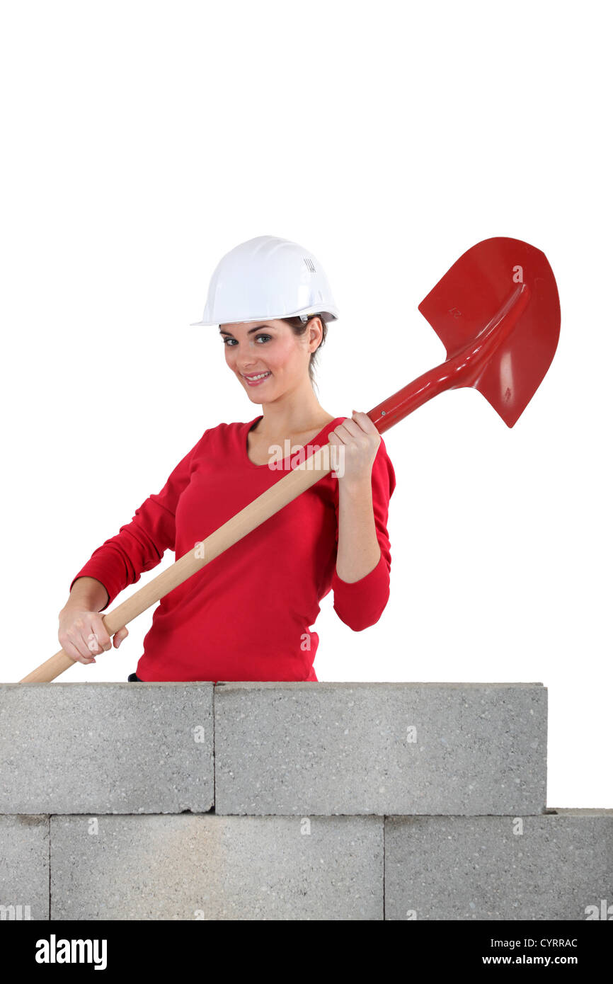 Woman mason holding a shovel Stock Photo - Alamy