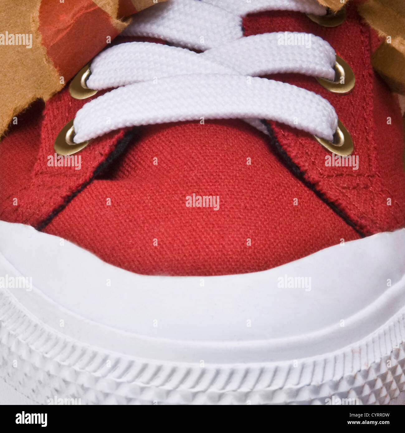 Close-up of a canvas shoe emerging from a torn paper bag Stock Photo ...