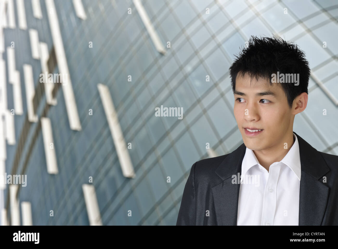 Asian businessman look away against office building background Stock ...