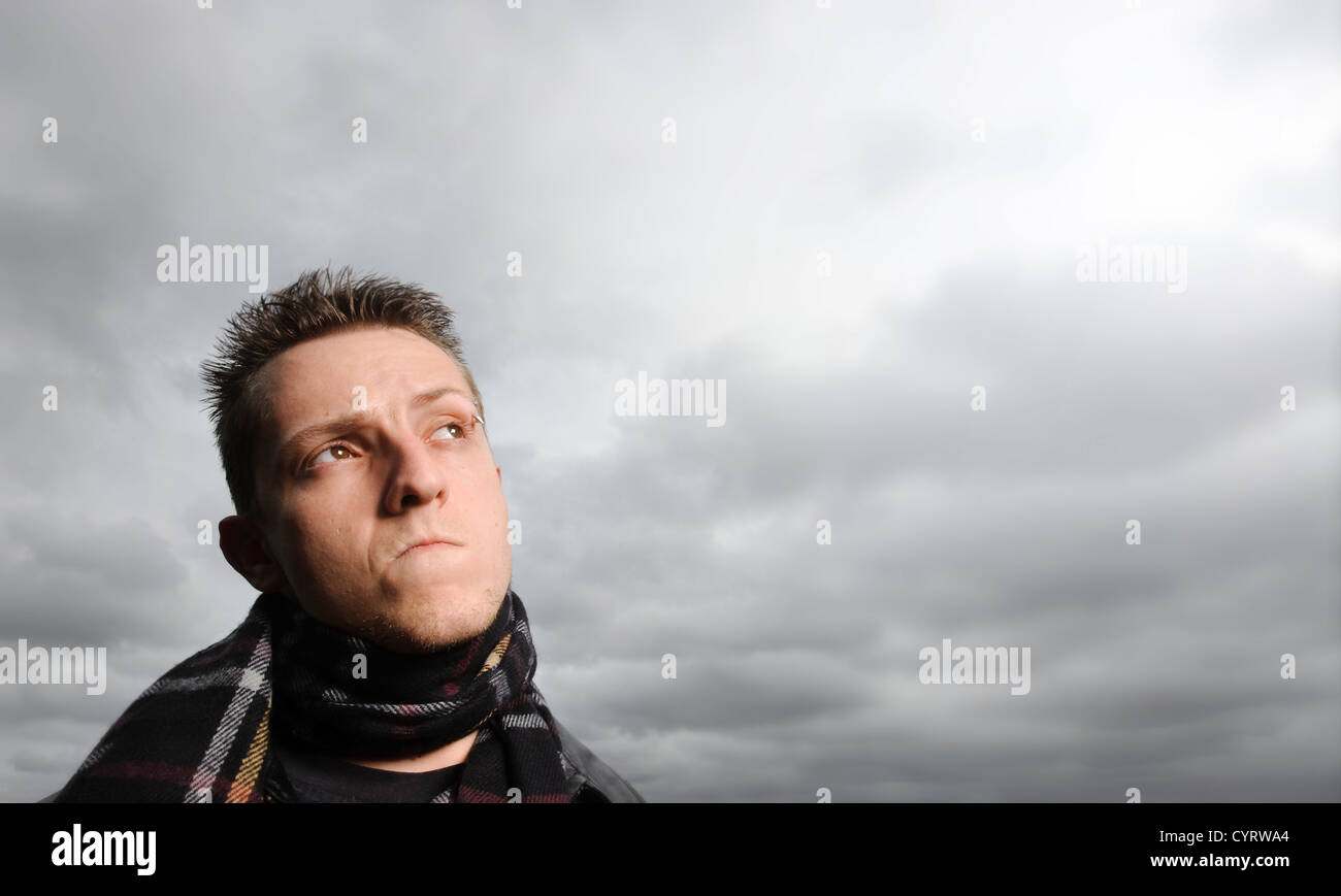 Young man looks up at the clouds above Stock Photo - Alamy