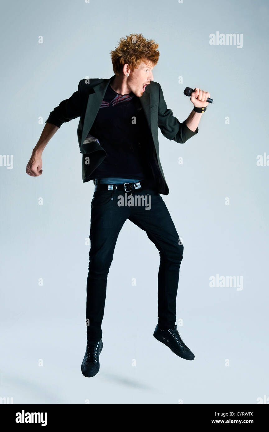 Rock star jumps and sings into the mic Stock Photo - Alamy