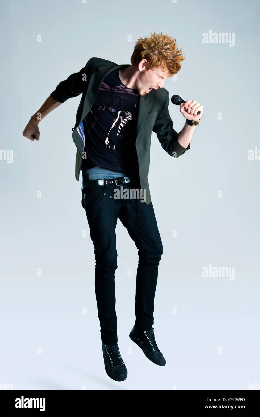 Rock star jumps and sings into the mic Stock Photo - Alamy