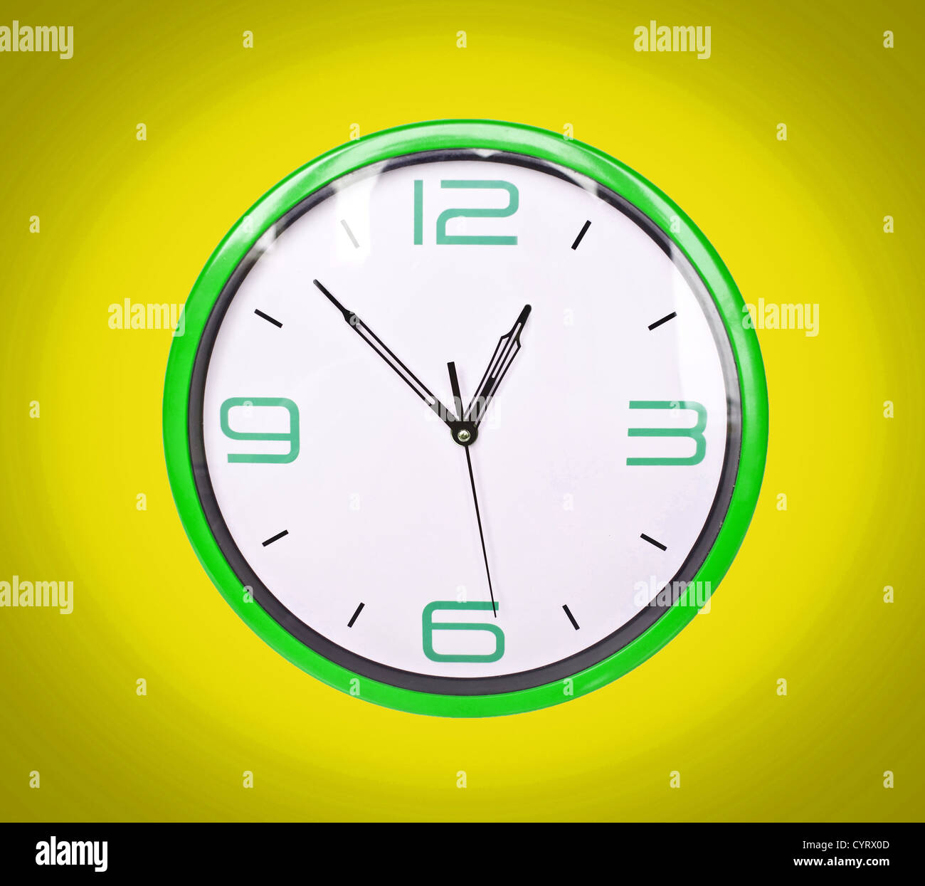Retro green clock on yellow background Stock Photo - Alamy