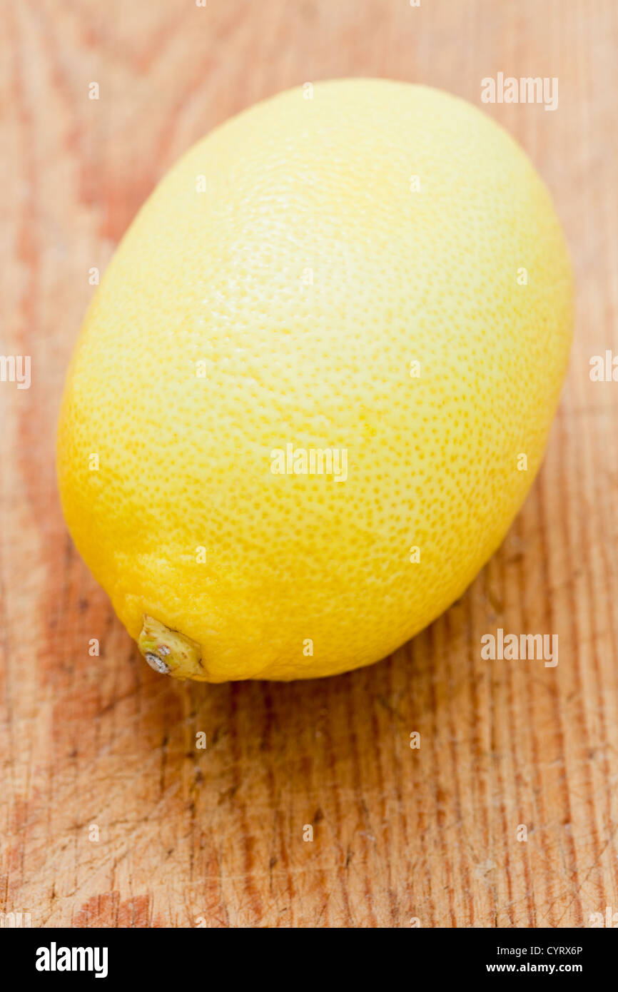 Single whole lemon on a wooden board Stock Photo - Alamy