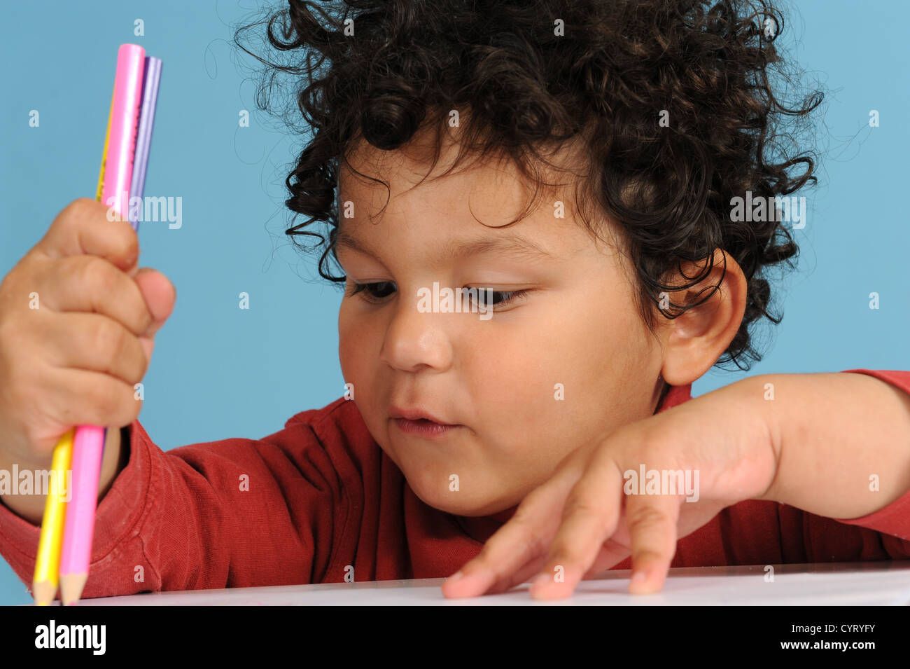 little boy drawing with pencils on blue Stock Photo - Alamy