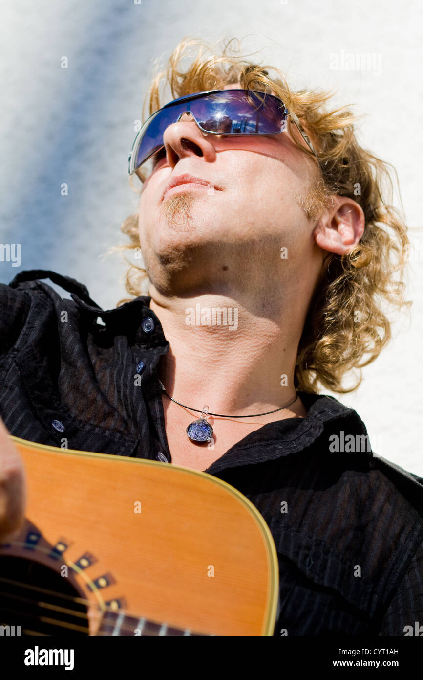 Rock star with acoustic guitar performing live in the summer Stock ...