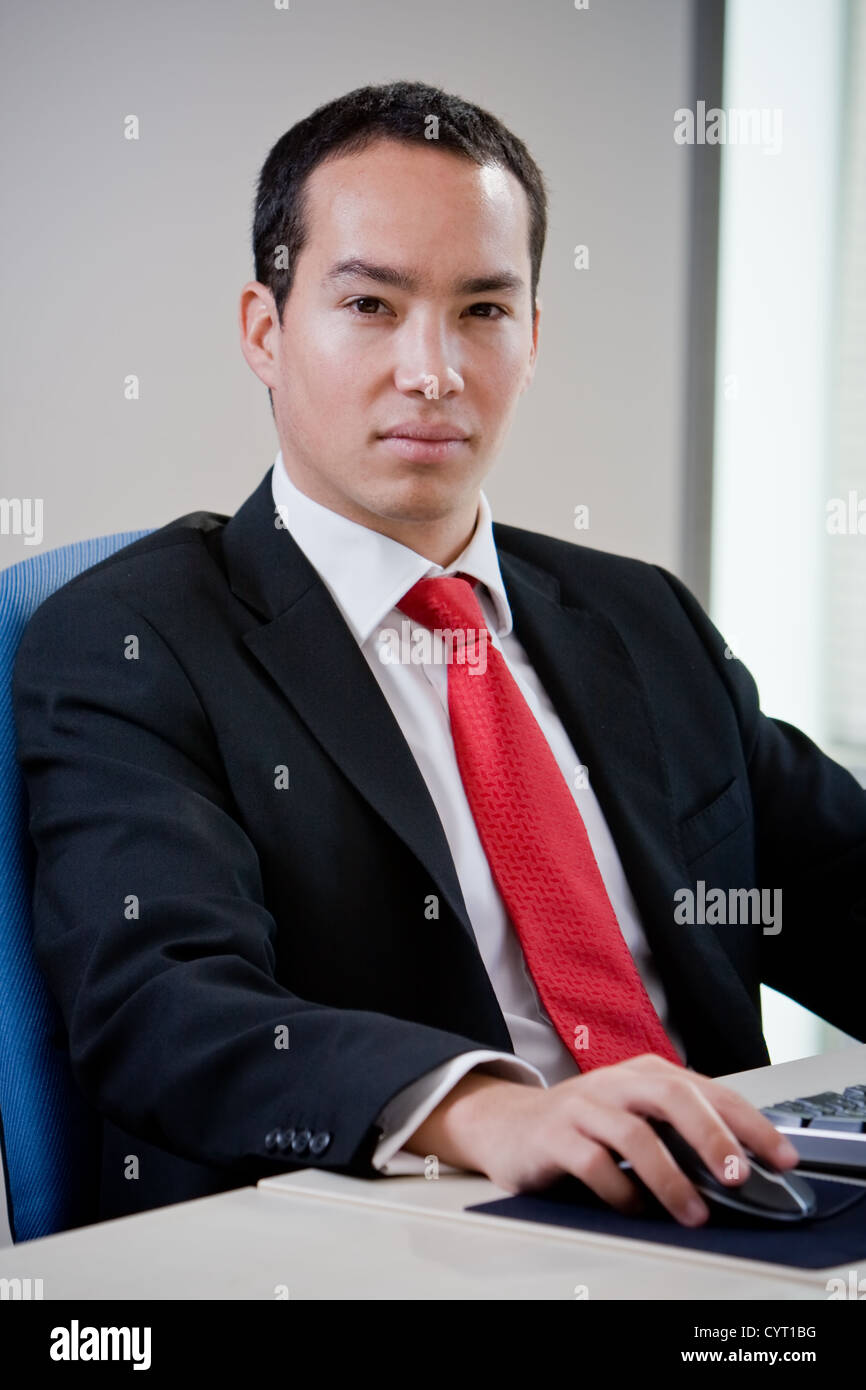 Handsome asian chinese business man using computer holding the mouse ...