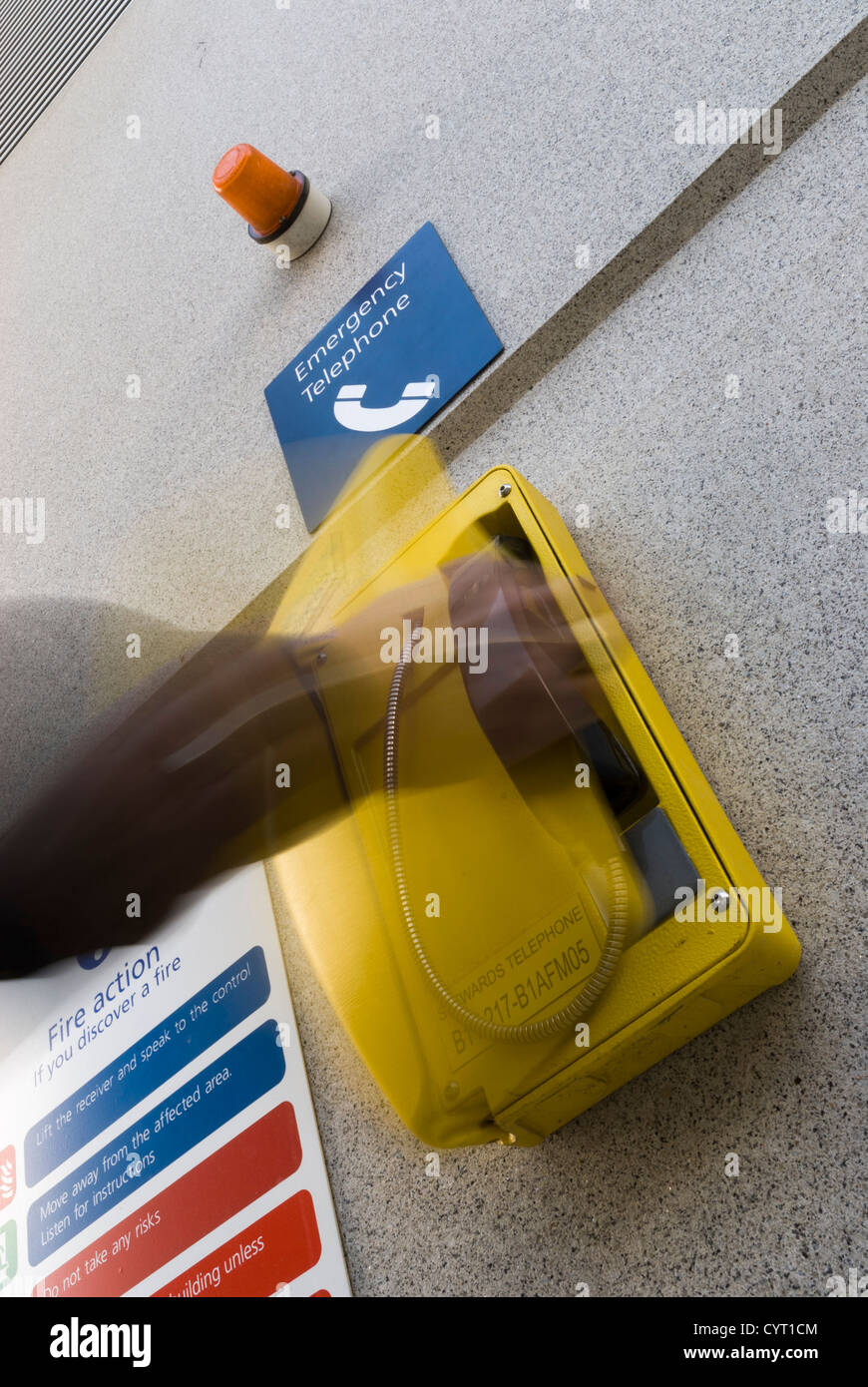 movement of hand reaching for yellow external emergency telephone on ...