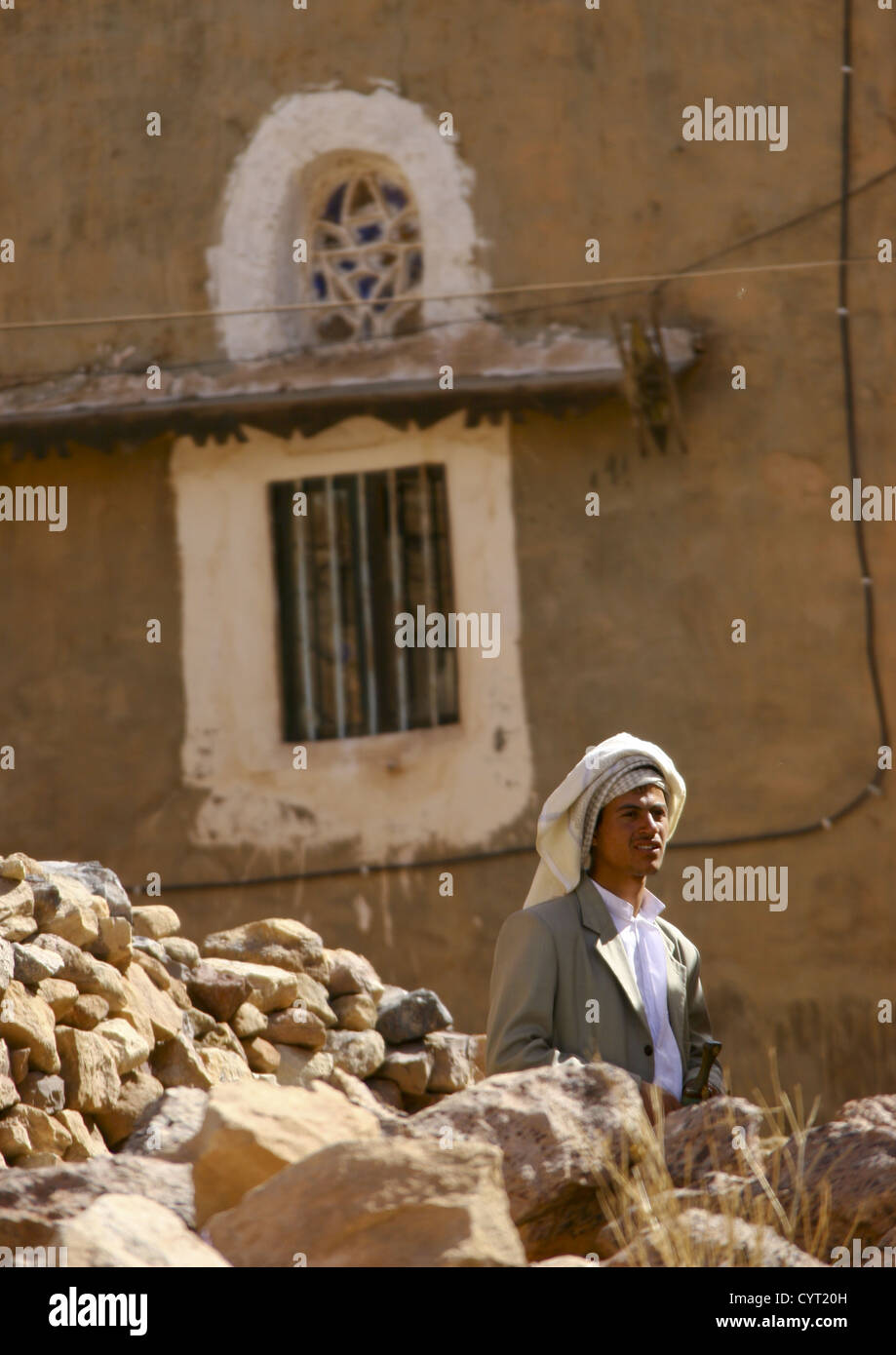 Young Man Passing Behind A Heap Of Stones, Ina, Yemen Stock Photo - Alamy