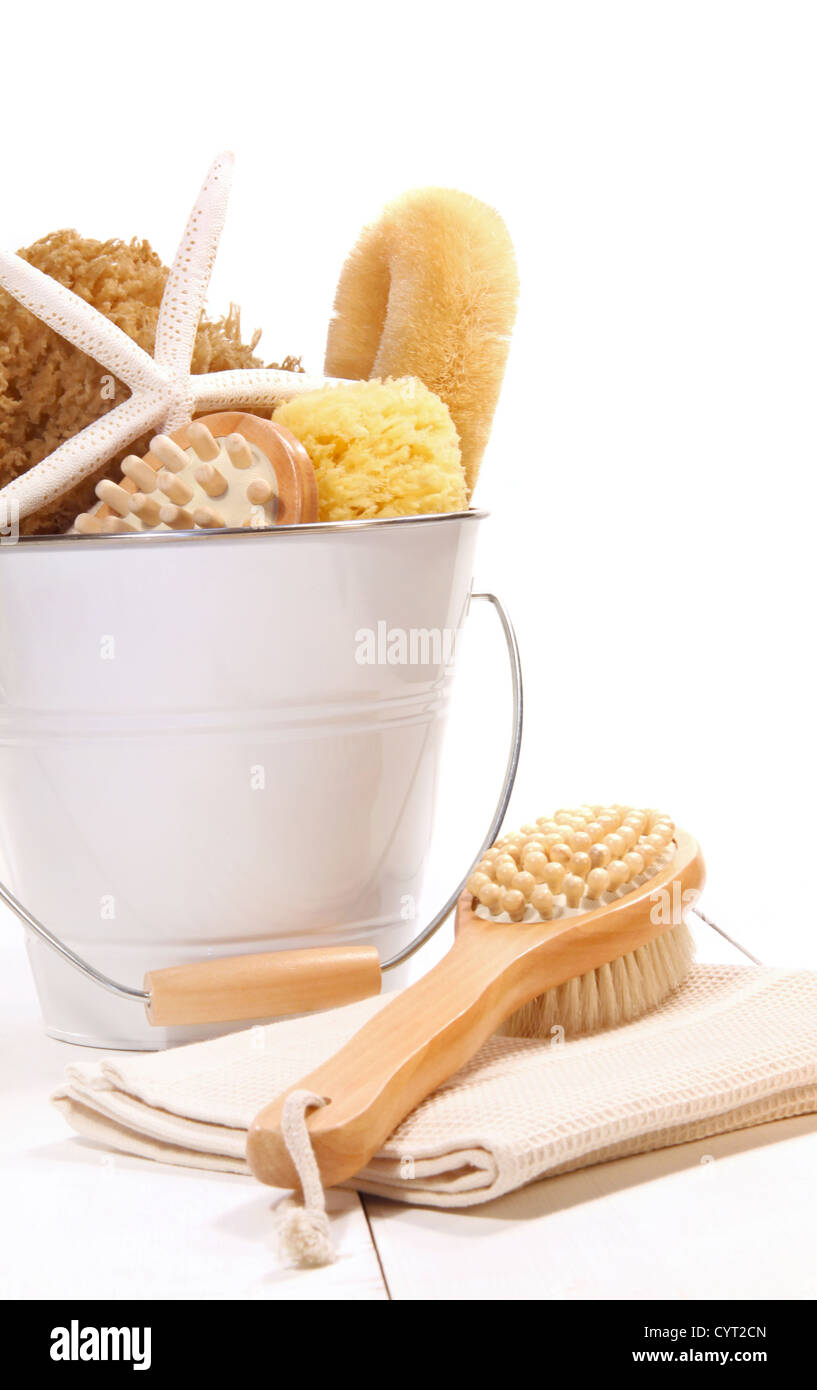 White bucket filled with sponges, scrub brushes and starfish on white ...