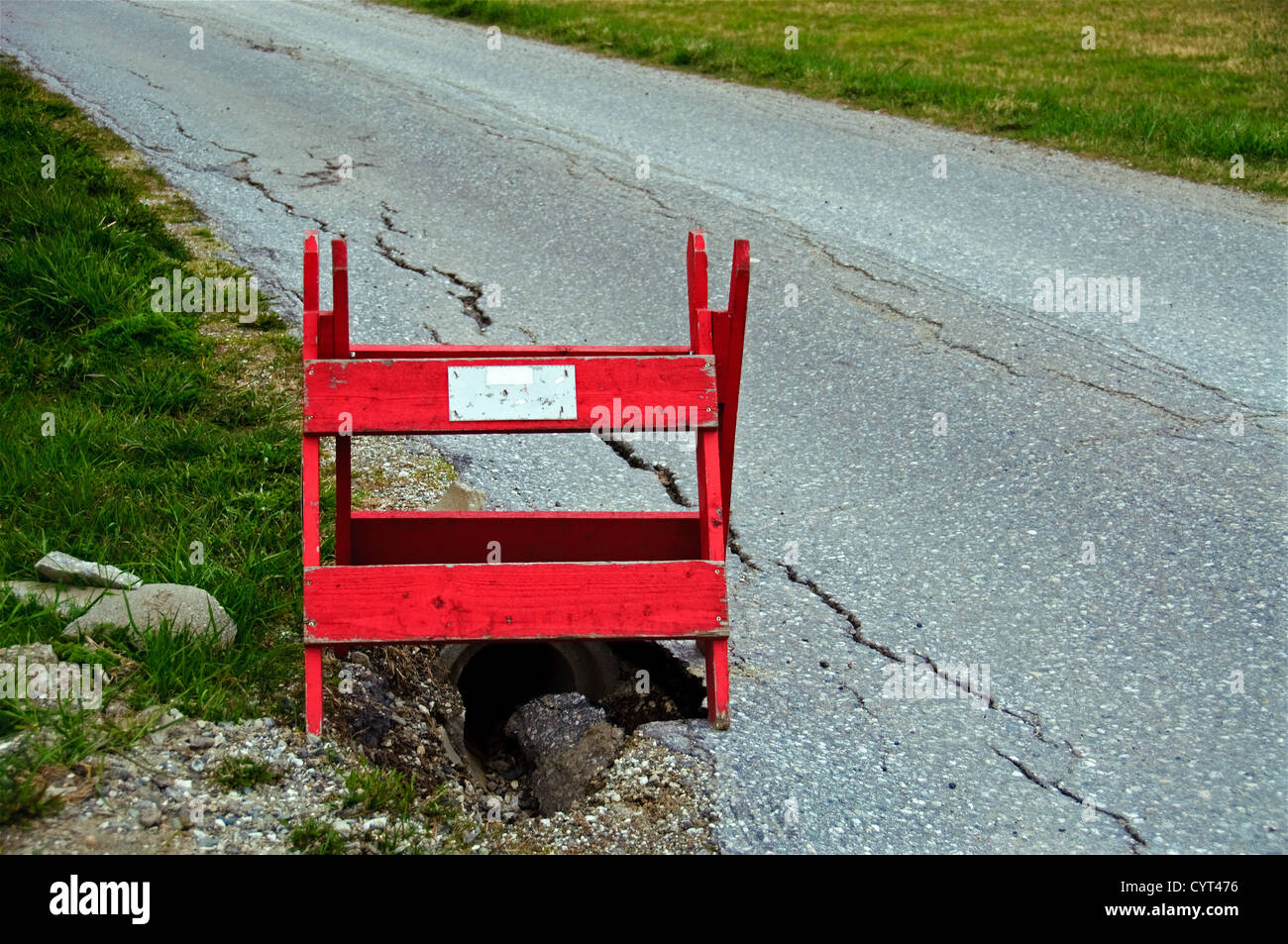 A red wooden roadblock on a bumpy road Stock Photo - Alamy