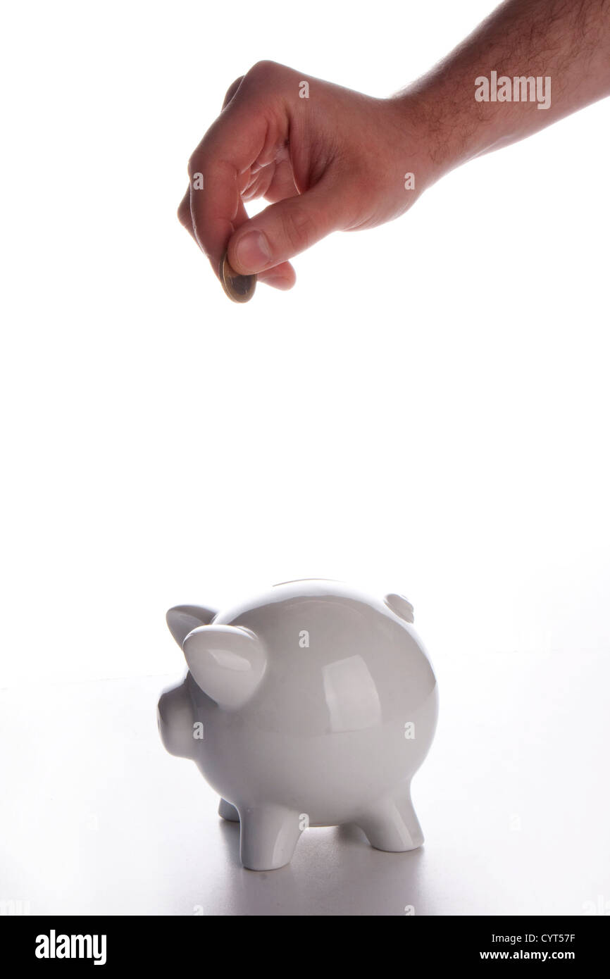 male hand dropping a coin of one euro into a white piggy bank Stock ...