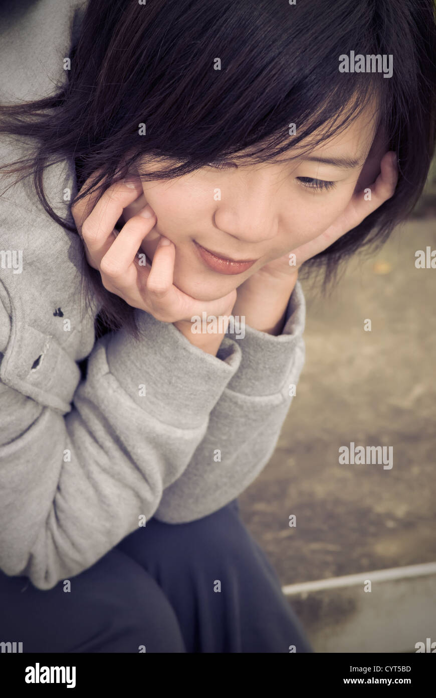 Blue Asian woman sit in outdoor waiting alone Stock Photo - Alamy