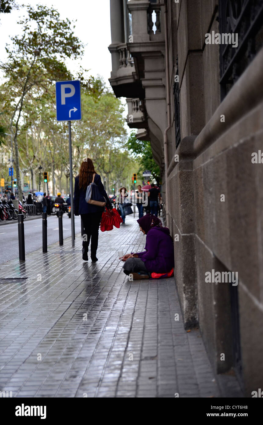 A beggar in Diagonal street in a rainy day Stock Photo - Alamy