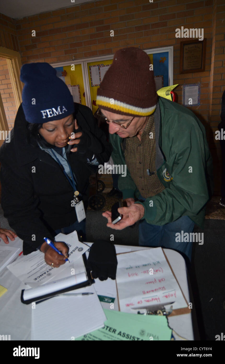 A FEMA community relations worker provides assistance to a resident in ...