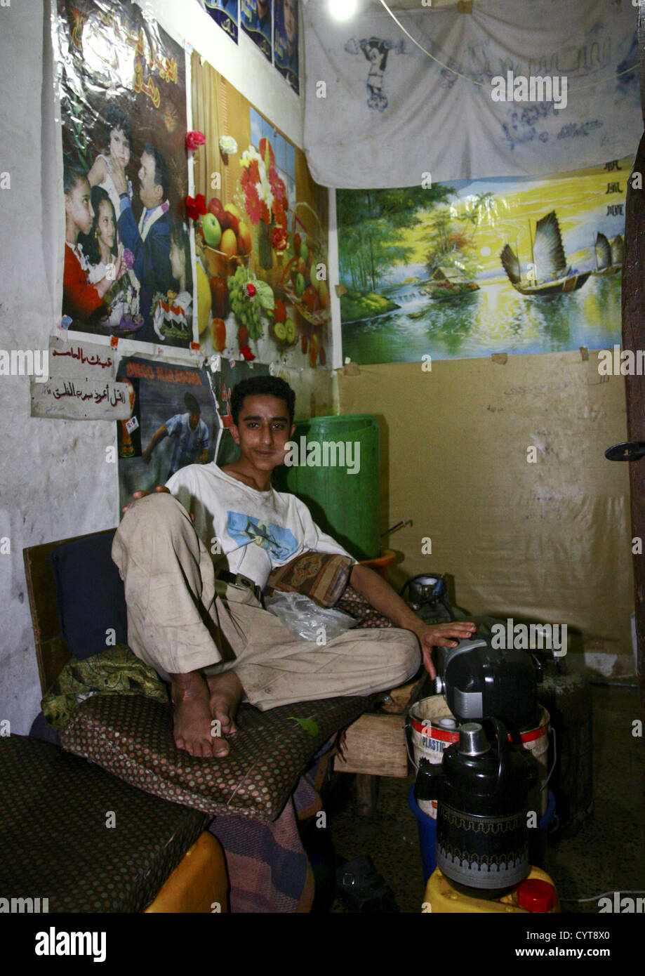 Young Man Lying Down And Chewing Qat In A Room Full Of Posters, Sanaa ...