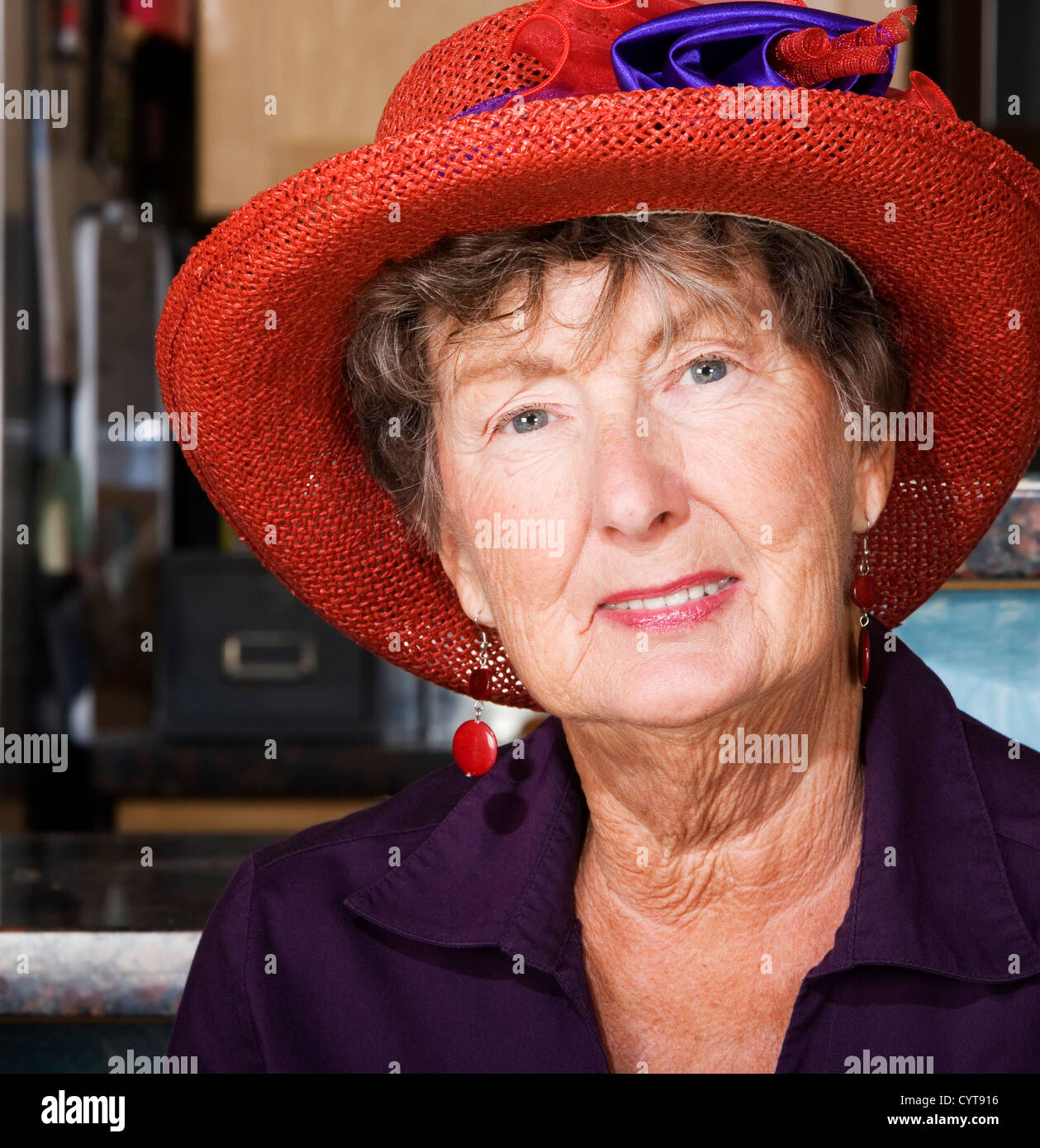 Friendly senior woman wearing a red hat Stock Photo - Alamy
