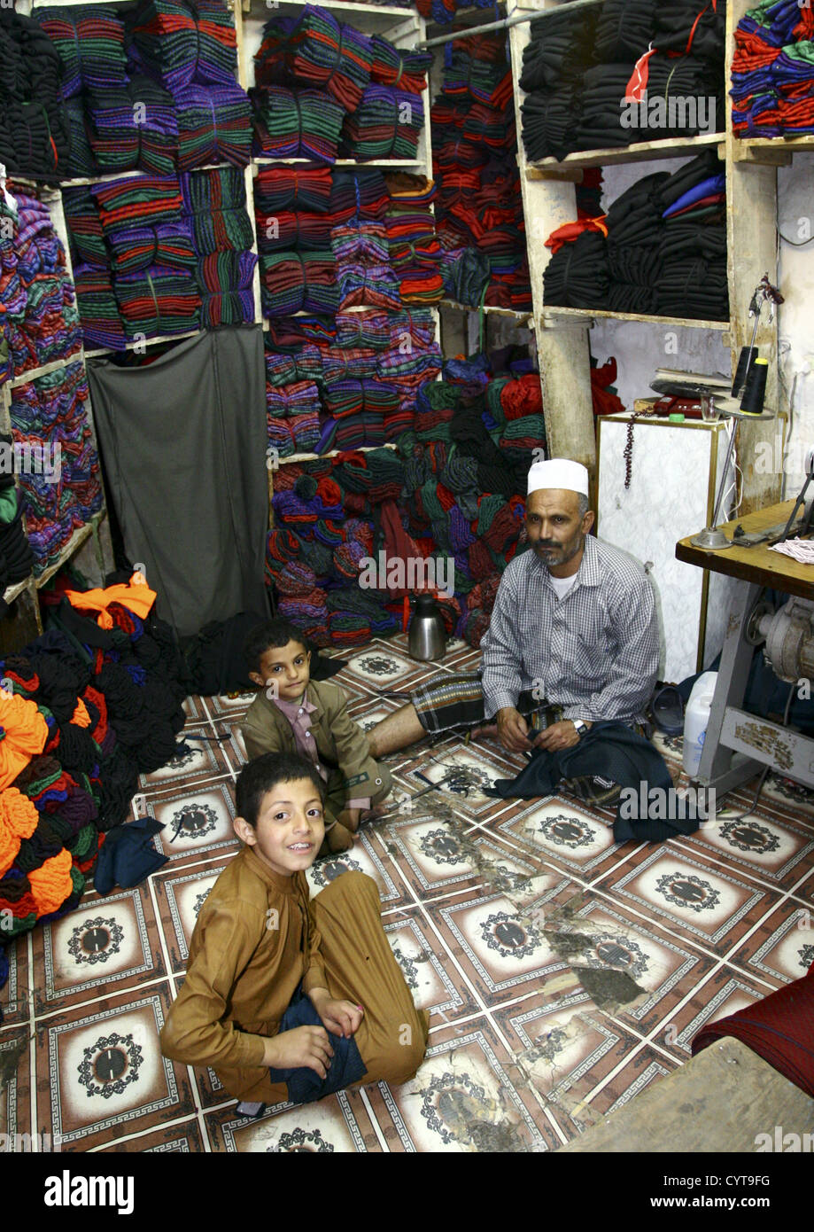 Shopkeeper With Two Kids Sitting On The Ground In Sanaa Old Souq, Yemen ...