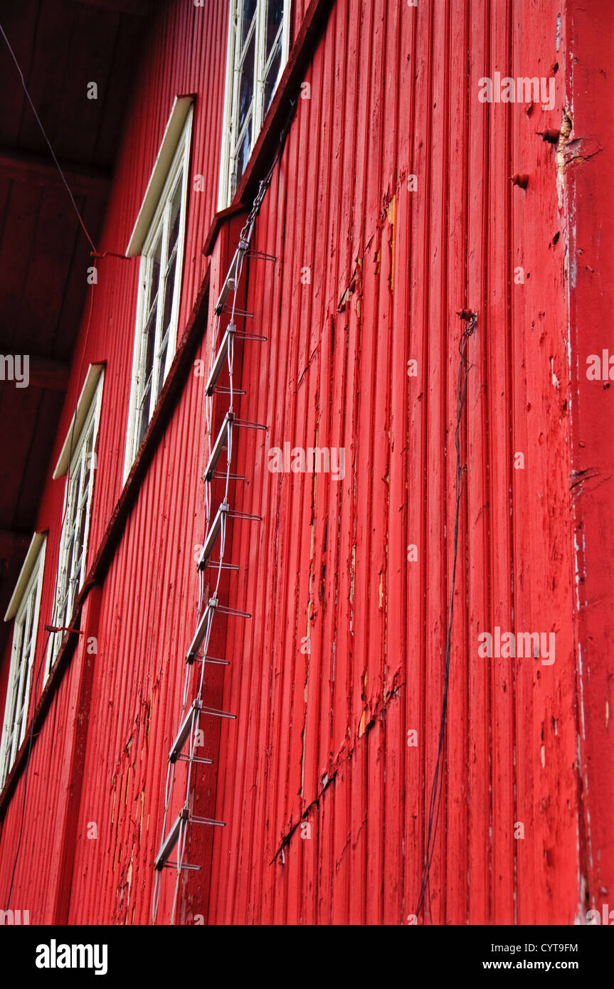 A ladder from a window on a red wooden house Stock Photo - Alamy