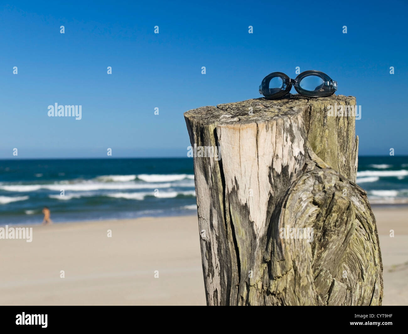 A pair of goggles sitting over a log in the beach Stock Photo - Alamy