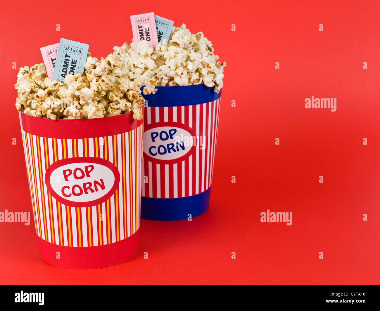 Two popcorn buckets over a red background. Movie stubs sitting over the ...
