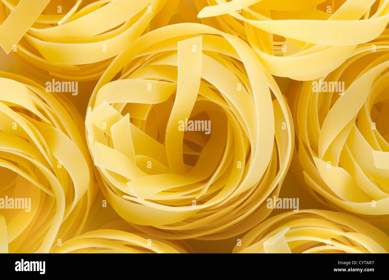 Photo of the yellow raw pasta background Stock Photo - Alamy