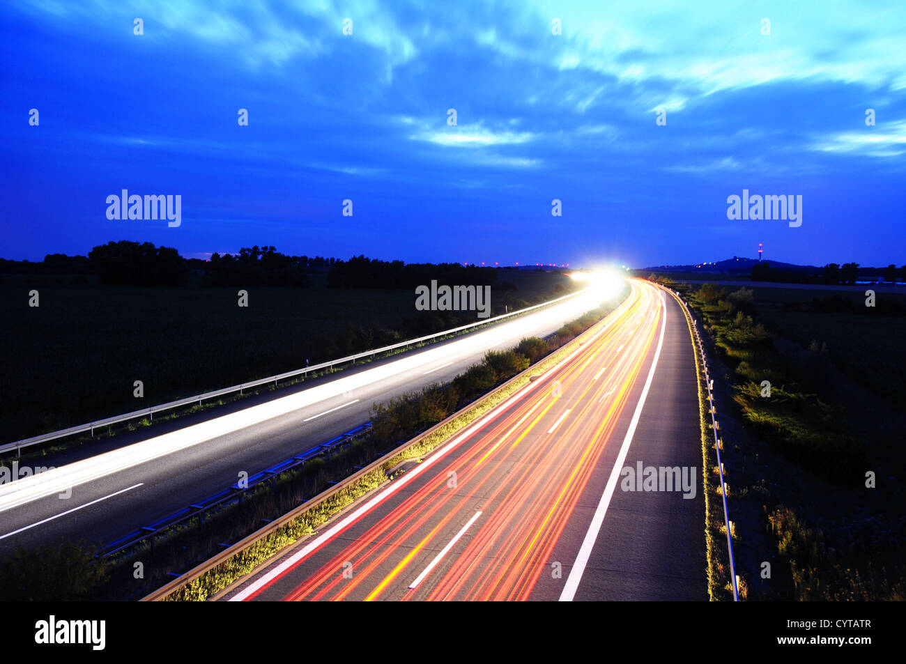 night traffic on busy highway with cars lights and blue sky Stock Photo ...