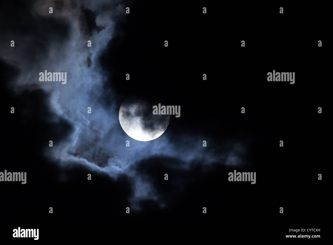 Full moon hiding behind dramatic storm clouds background Stock Photo ...