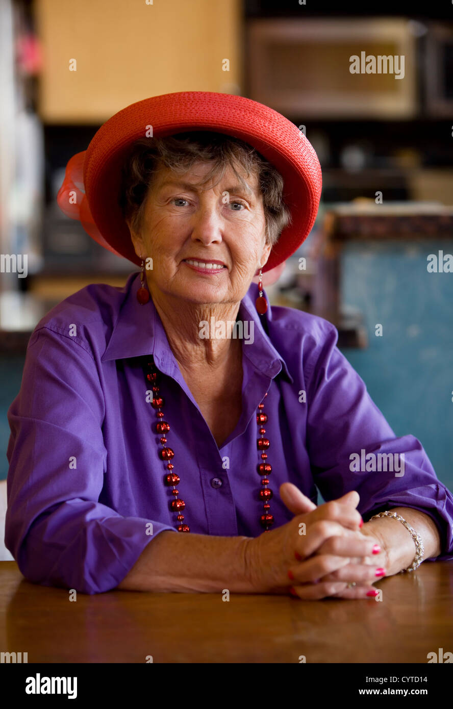 Friendly senior woman wearing a red hat Stock Photo - Alamy