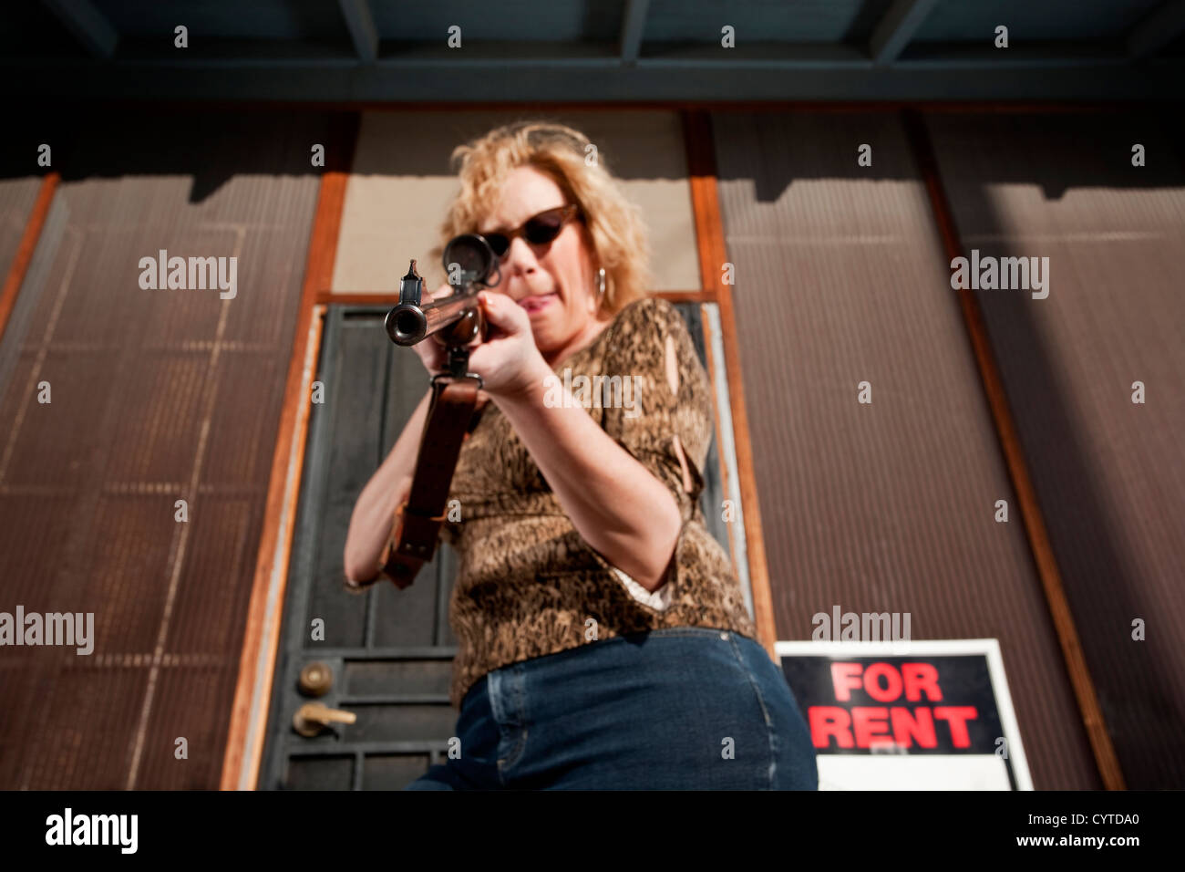 Blonde woman on her front porch with a rifle Stock Photo - Alamy