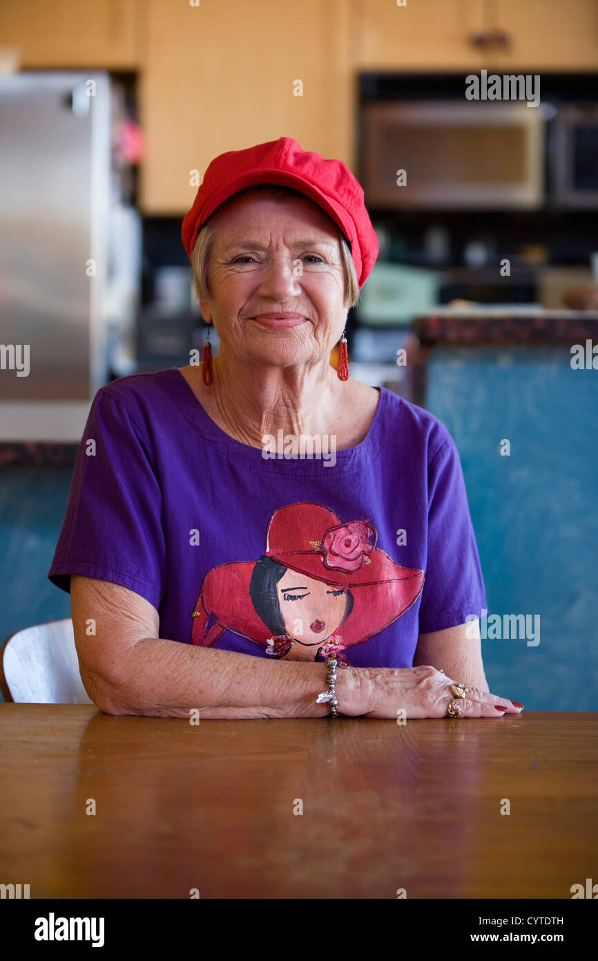 Friendly senior woman wearing a red hat Stock Photo - Alamy