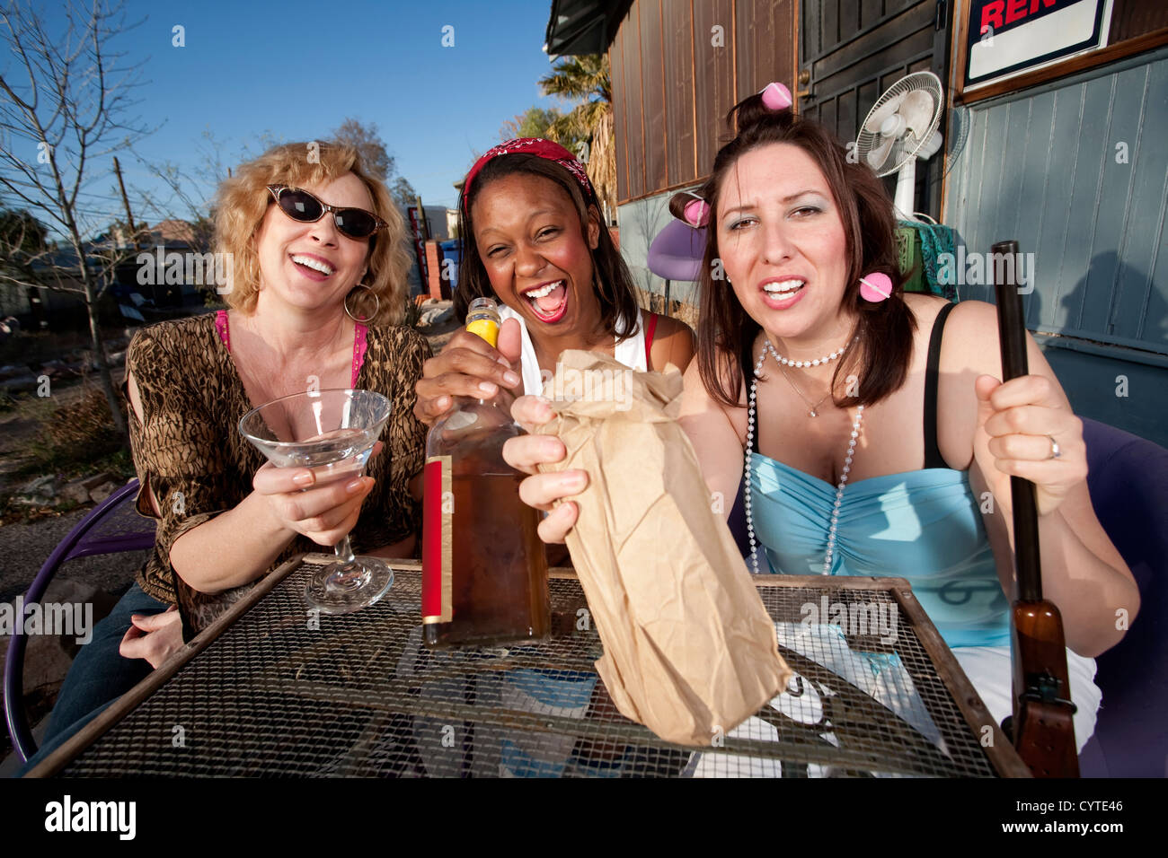 Three women outside a house drinking alcoholic beverages Stock Photo ...