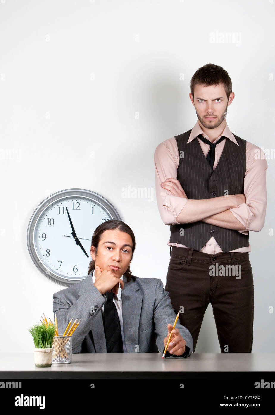 Bored man at work with an angry coworker behind him Stock Photo - Alamy