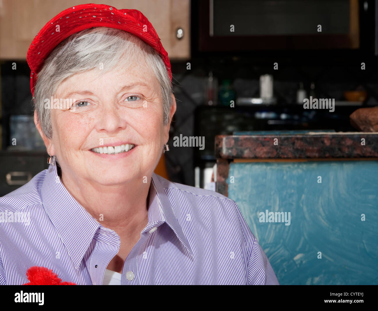 Friendly senior woman wearing a red hat Stock Photo - Alamy