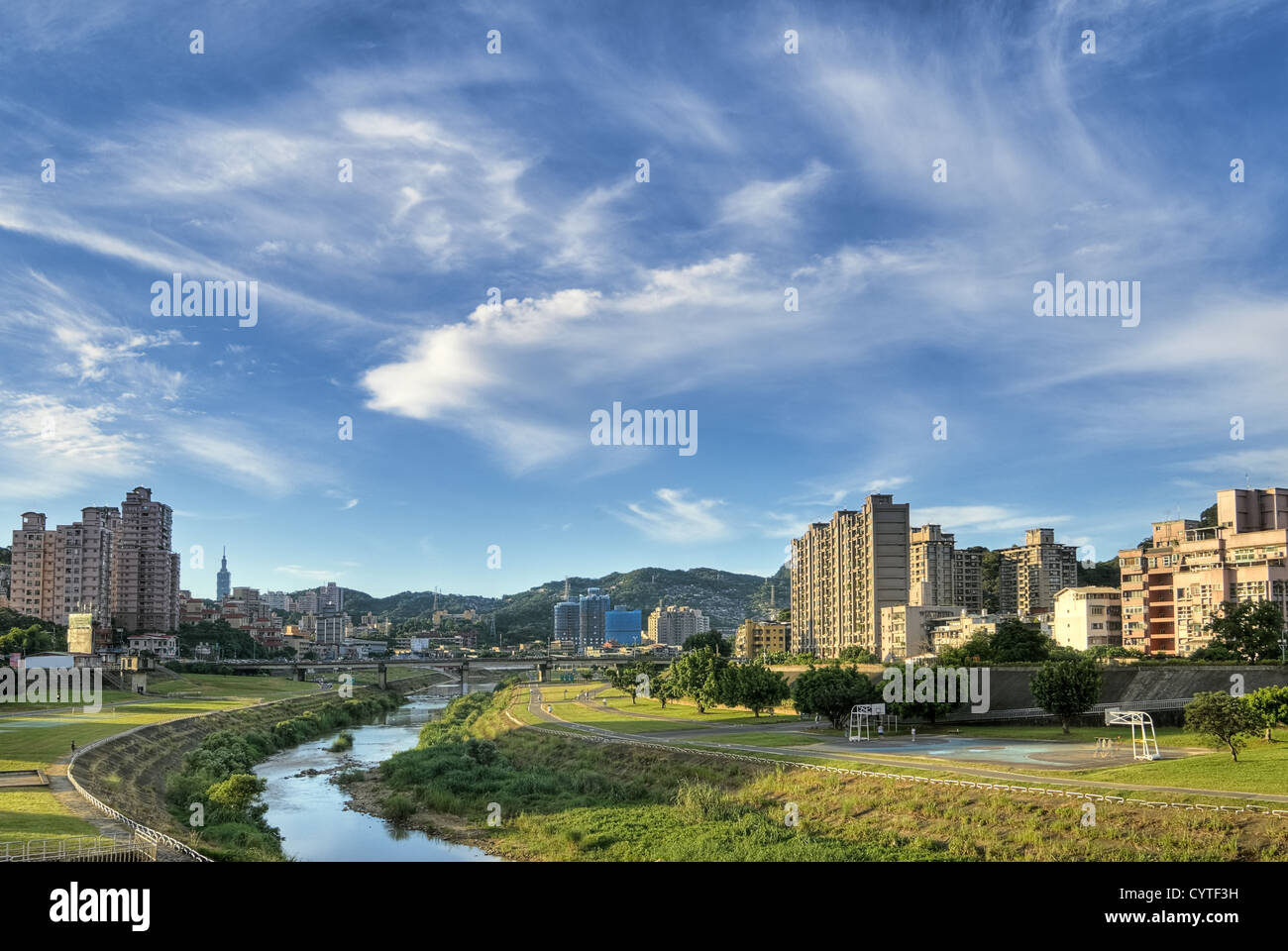 City scenery of park and river under blue sky and white clouds in ...