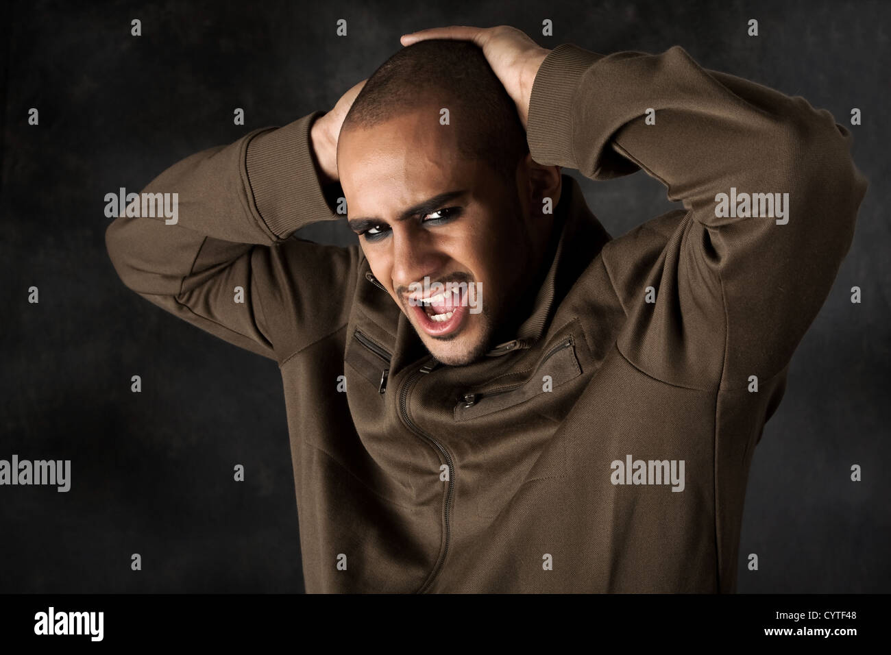 Handsome African Hispanic guy frowning with strong mad macho expression ...