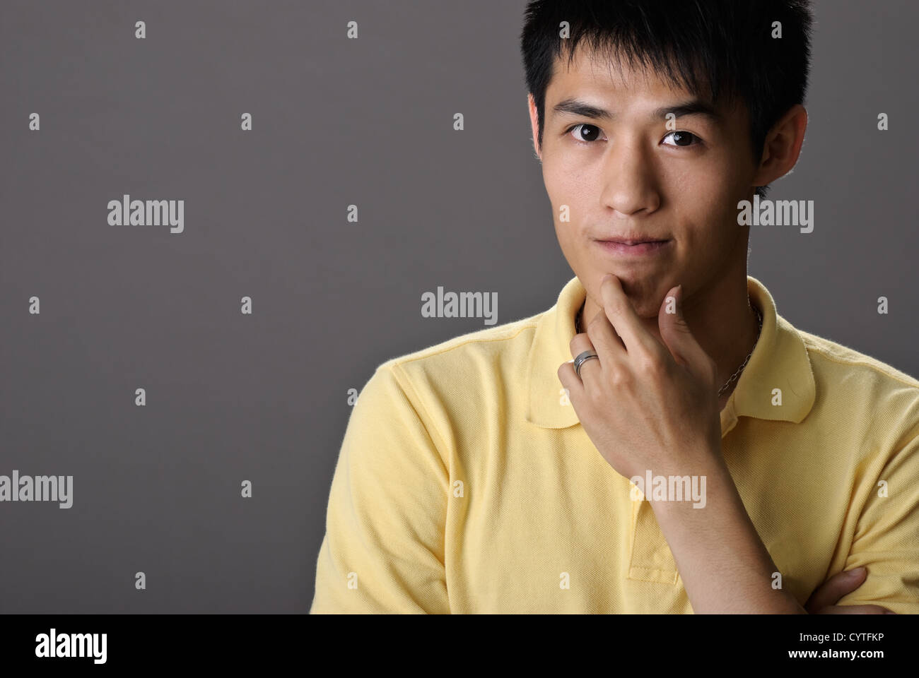Handsome young male of Asian thinking with copyspace Stock Photo - Alamy
