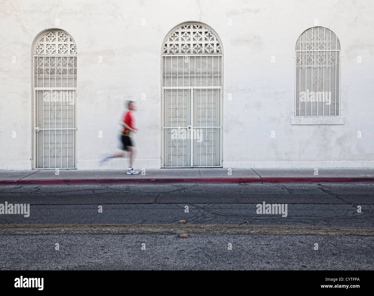 Man jogging down city street for exercise Stock Photo - Alamy