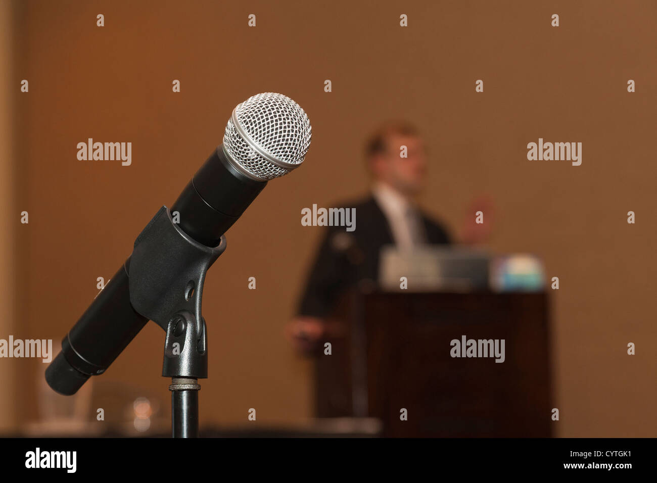 Microphone on stand with speaker in background Stock Photo - Alamy