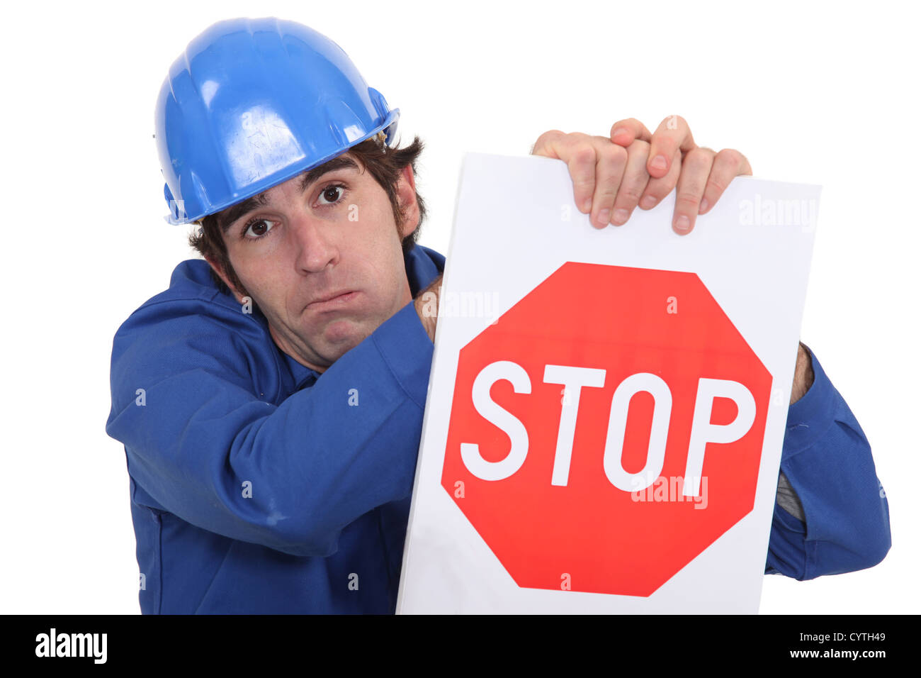 builder in jumpsuit holding stop sign Stock Photo - Alamy