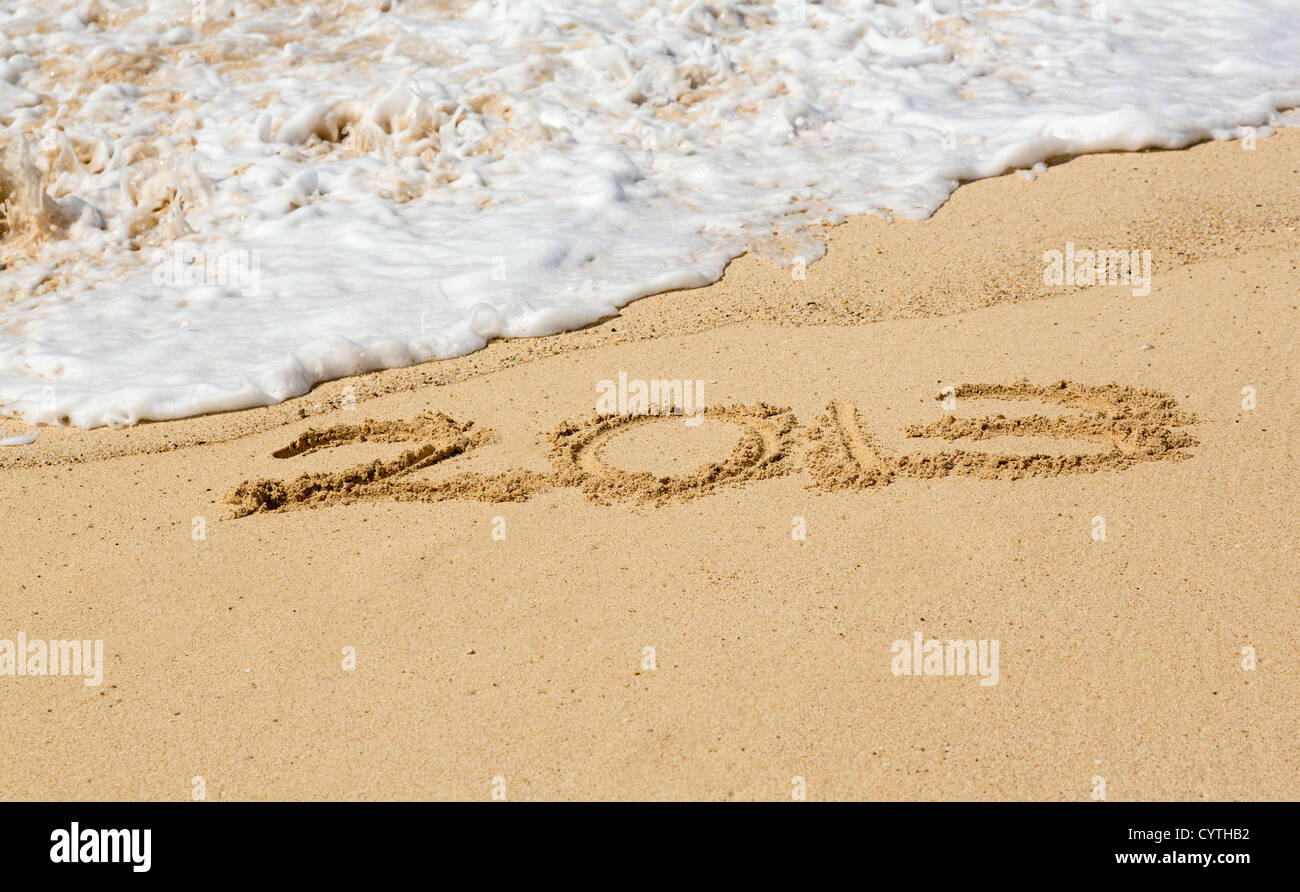 2013 written in sand on beach with sea waves starting to erase the word ...