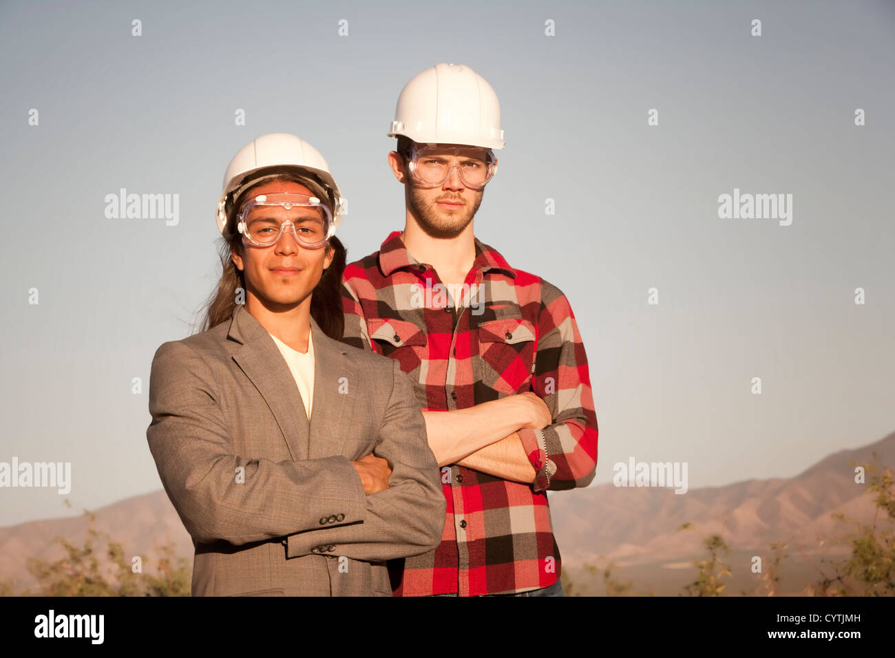 Two handsome men outdoors wearing protective hardhats Stock Photo - Alamy