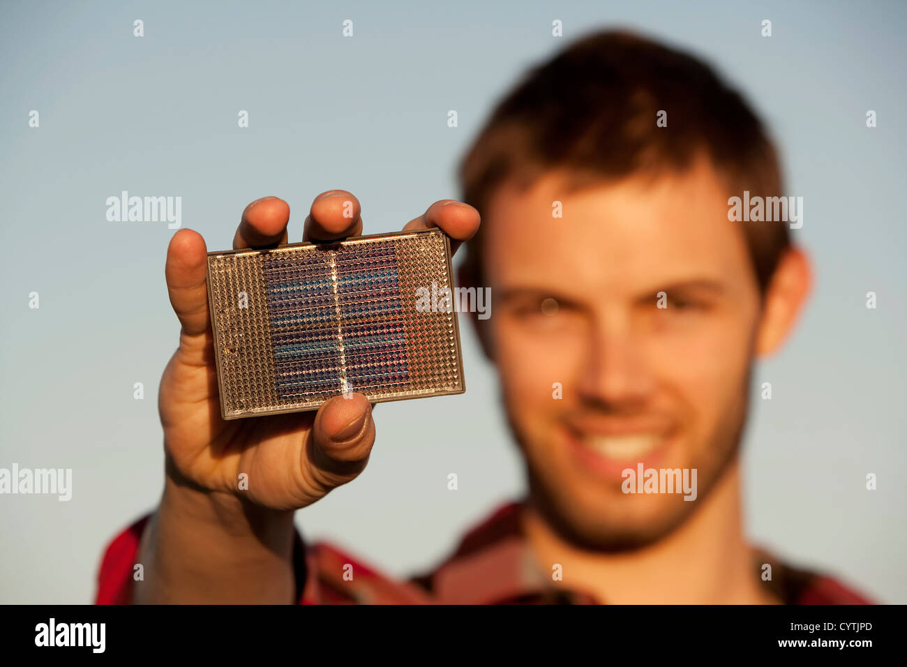 Handsome young man with small solar panel in hand Stock Photo - Alamy