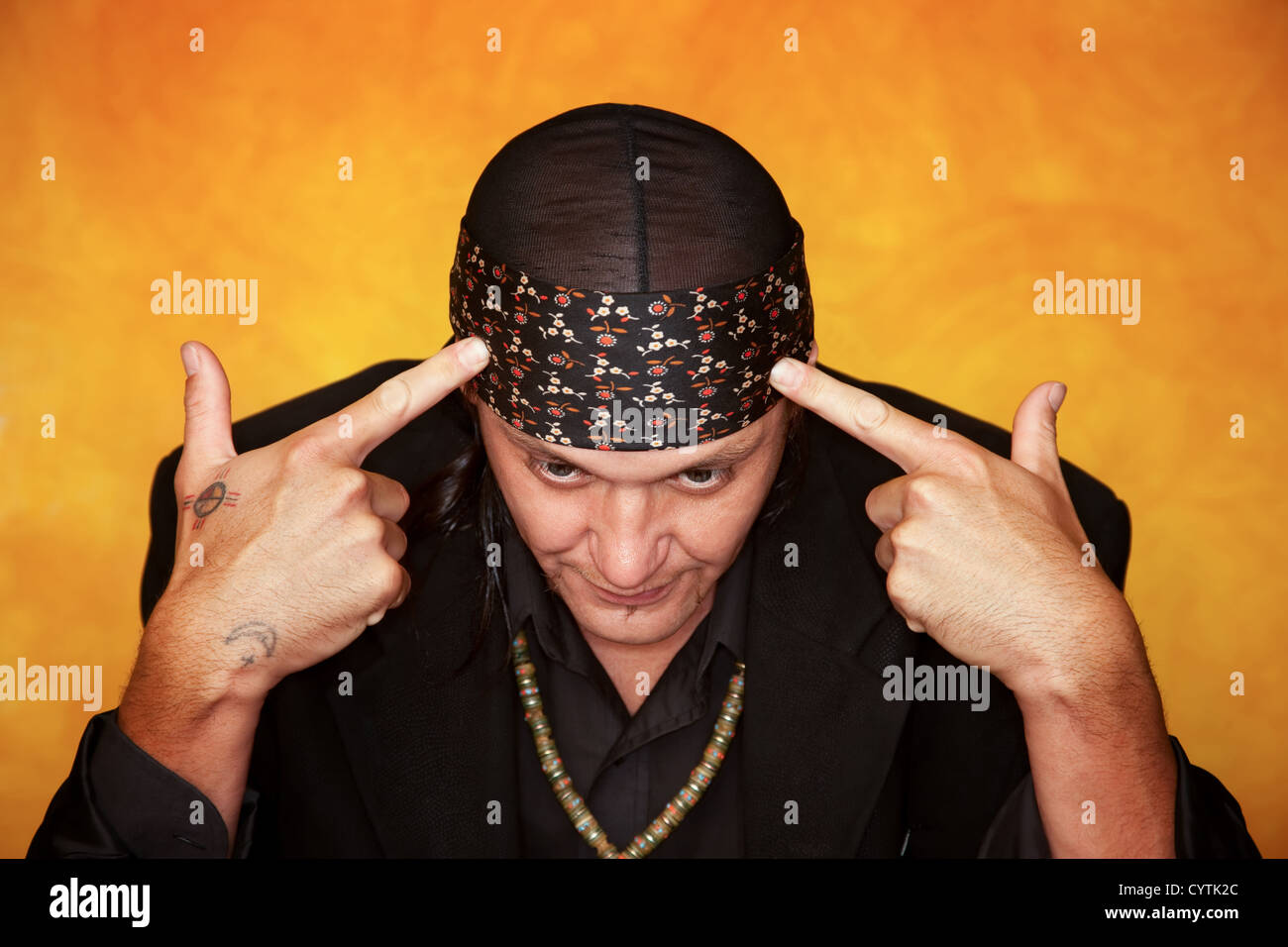 Handsome mixed race man with stern expression on his face pointing at ...