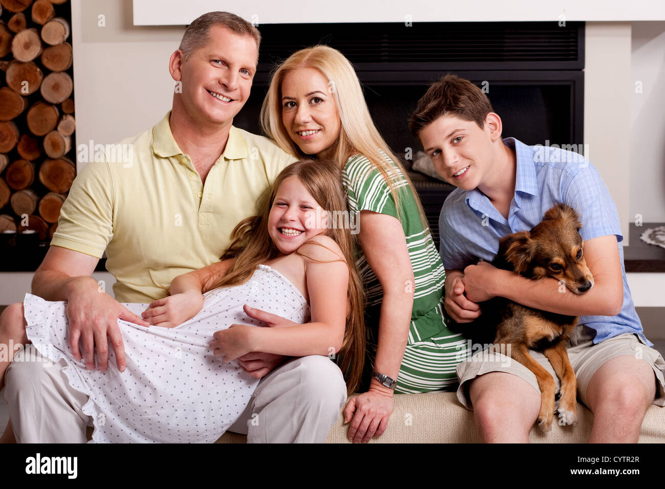 Lovable family poisng in living room as young boy holds little puppy in ...