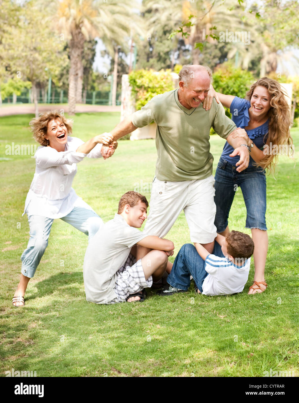 Family members holding back grandfather and having fun Stock Photo - Alamy