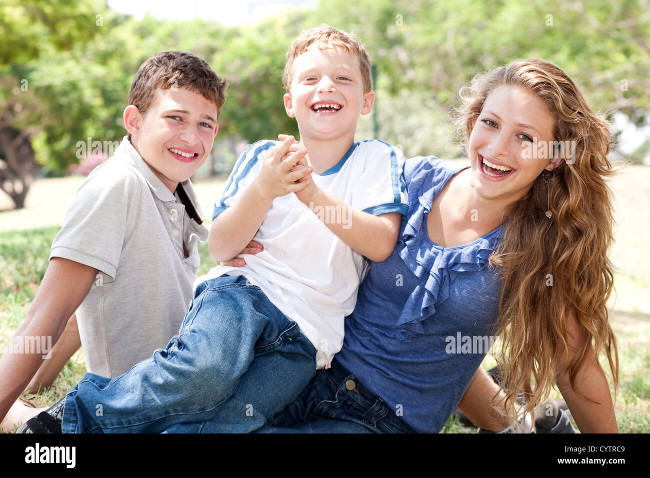 Kids having fun with mum and smiling at camera as they spend out day in ...