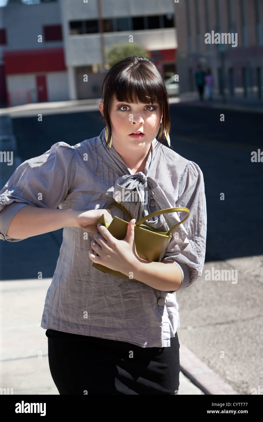 Young woman frantically searches purse on city block Stock Photo - Alamy