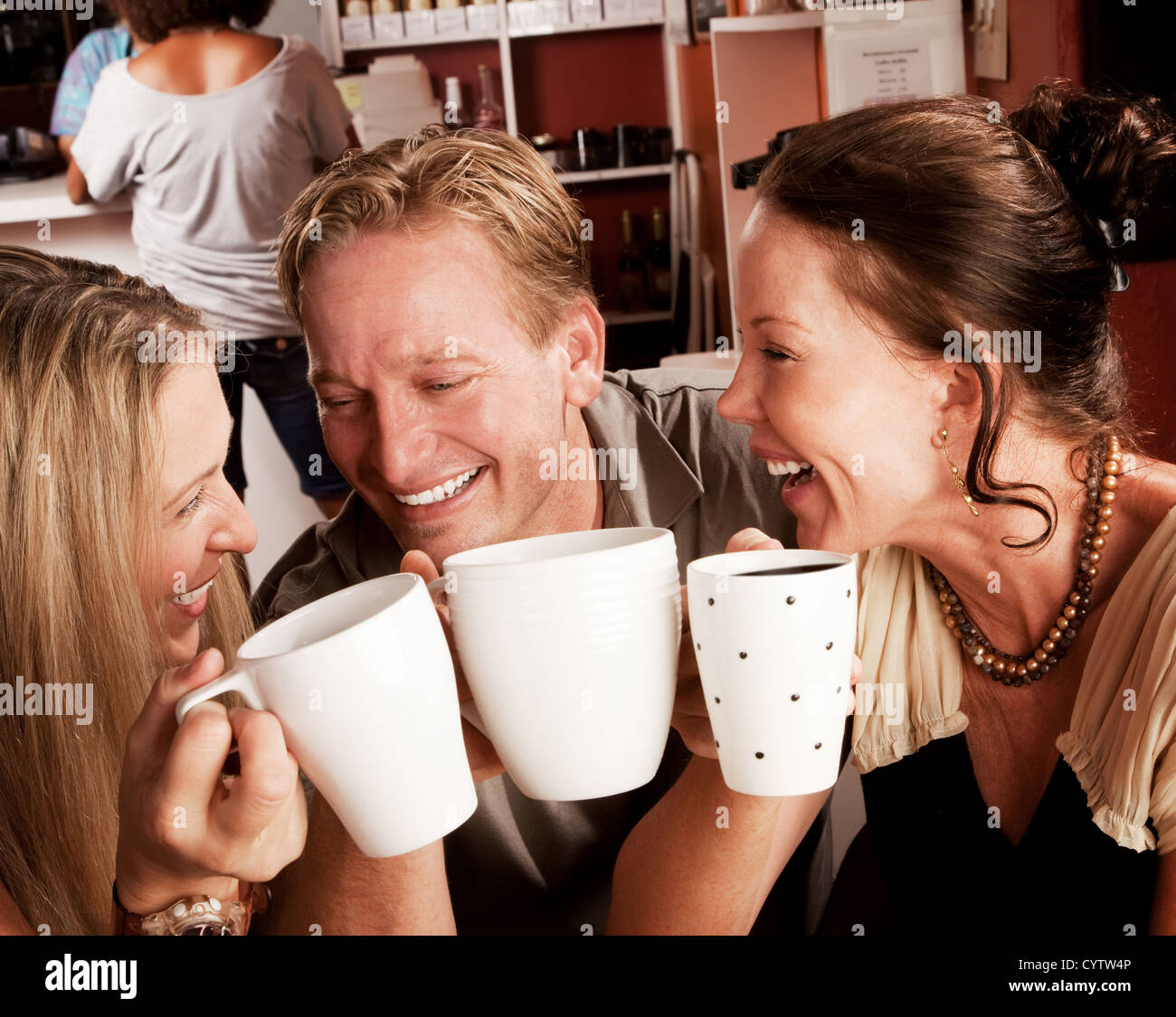 Three friends in a coffee house toasting with their cups Stock Photo ...