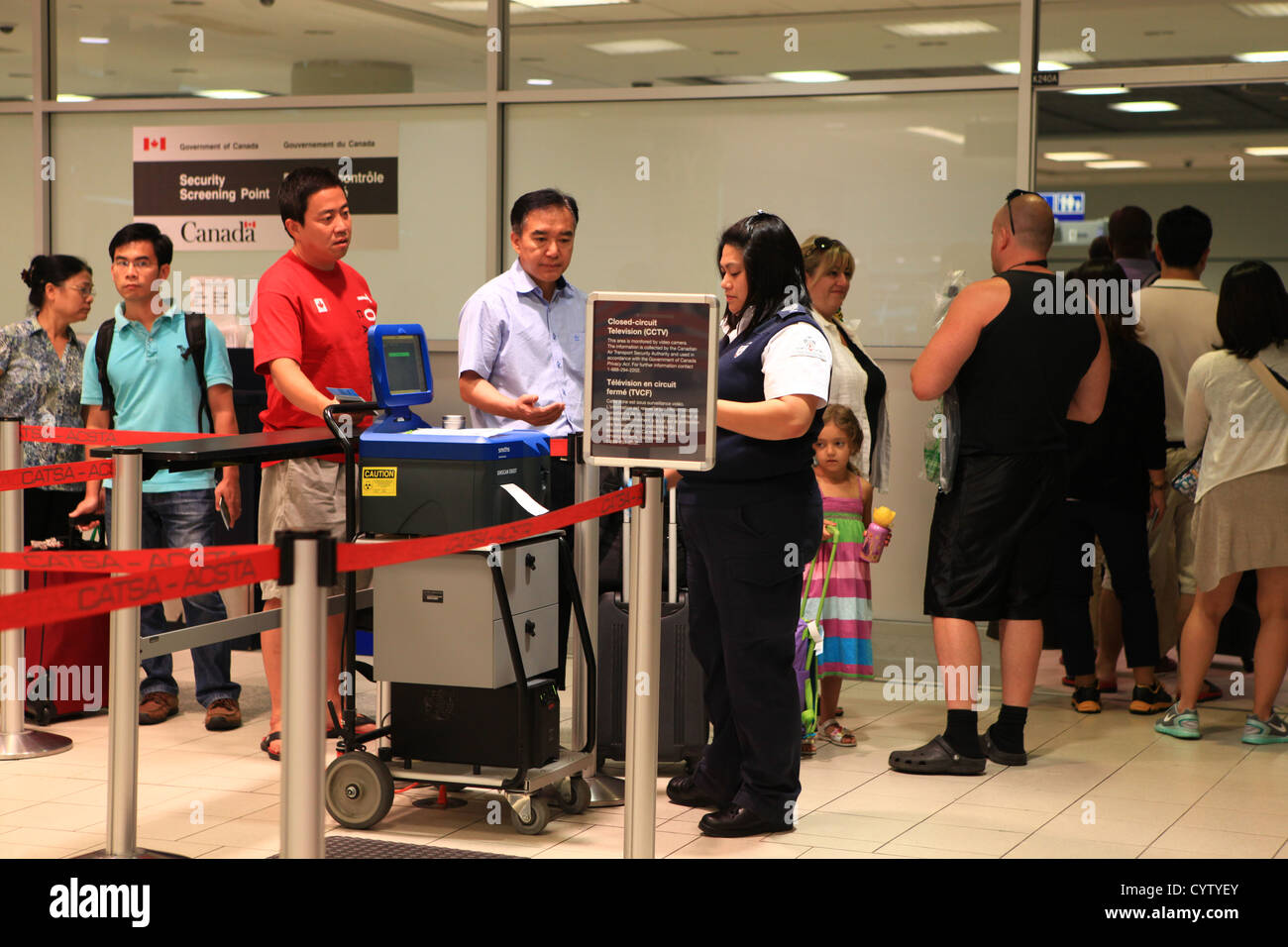Security officer checking passports of travelers at Toronto pearson ...